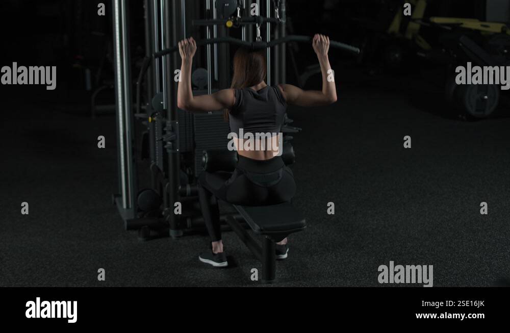 Female in the Gym lifting blocks on rack machine, back view, training ...