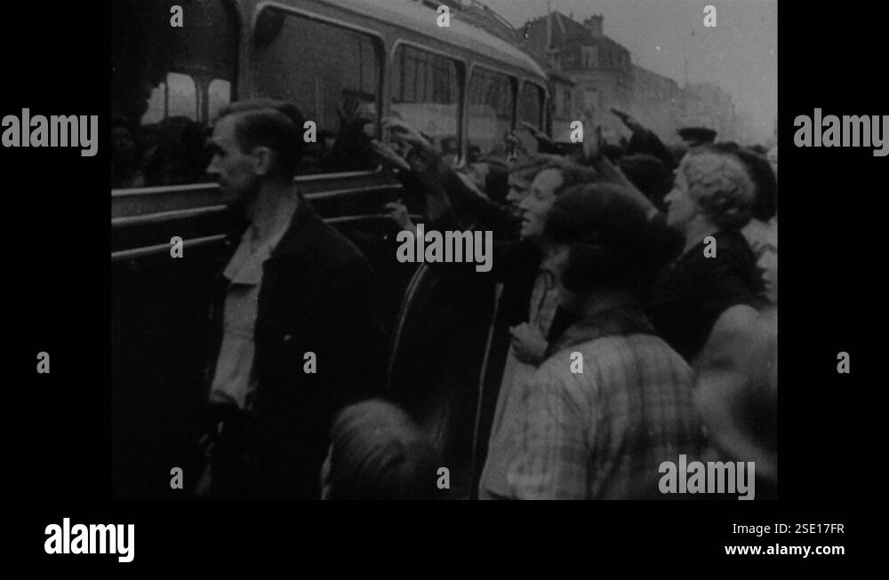 1940s: People say goodbye at train station. Child with patch on arm ...