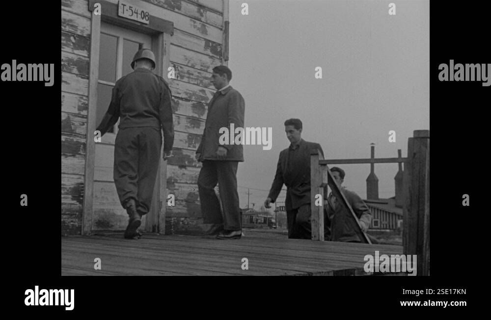 1950s: Soldiers eating at table. Men enter building. Men pick up ...