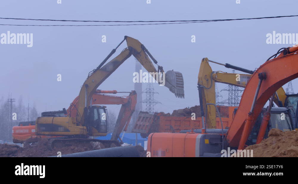 Excavation at a construction site, excavators loads the trucks with ...