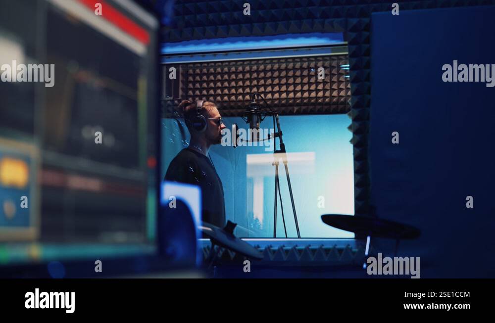 Male Rap Singer with Headphones and Sound Engineer are recording a new ...