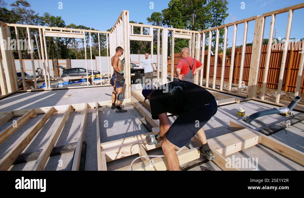 Timelapse of a frame house building site. Builders joint wooden planks ...
