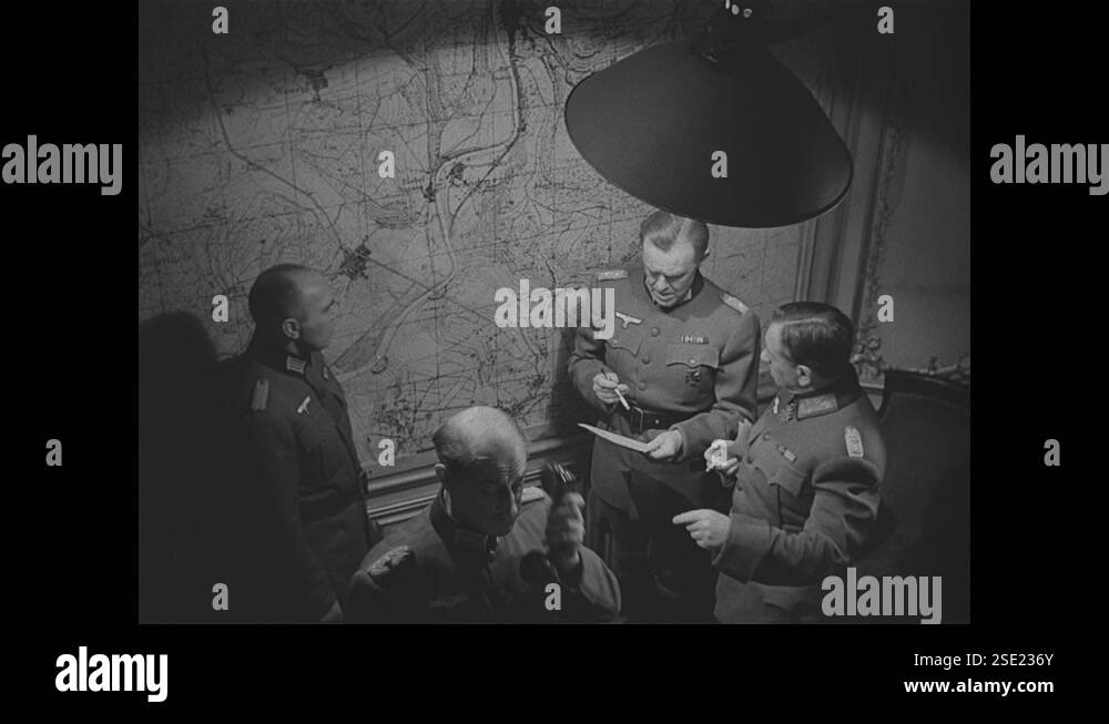1940s: Nazi officers speak and look at paper. Officer gestures at map ...