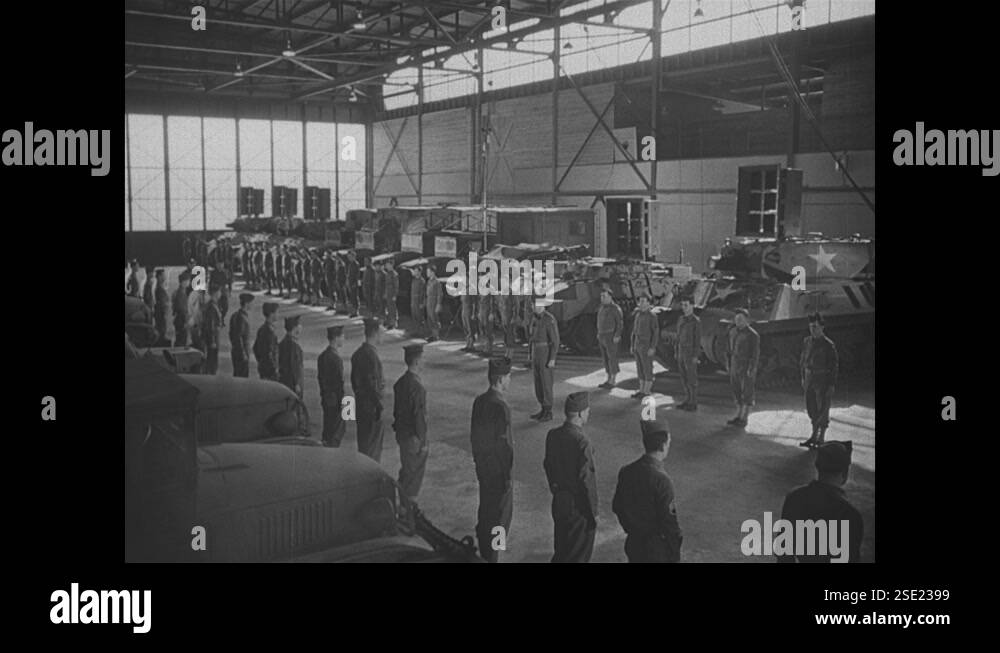 1940s: Soldiers stand at attention in garage with tanks. Military ...