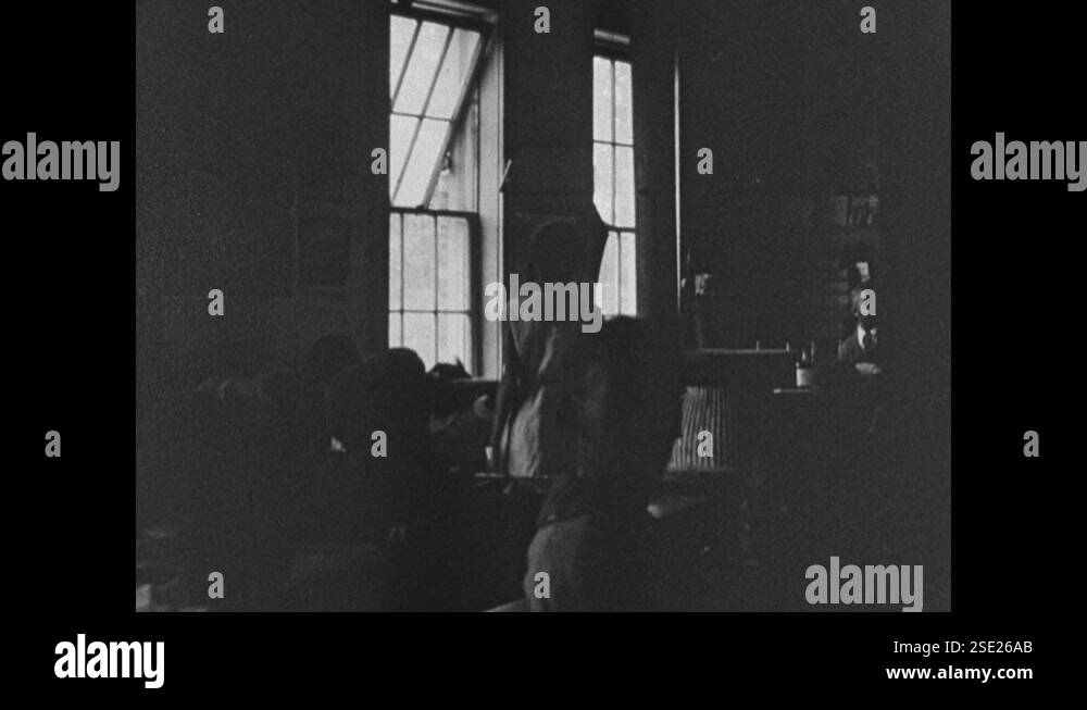 1930s: Looking through bars on window into empty room. People in room ...
