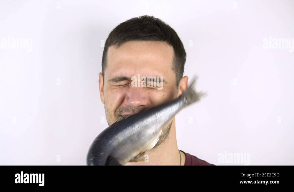 Young handsome guy gets hit in the face with a fresh fish Stock Video ...