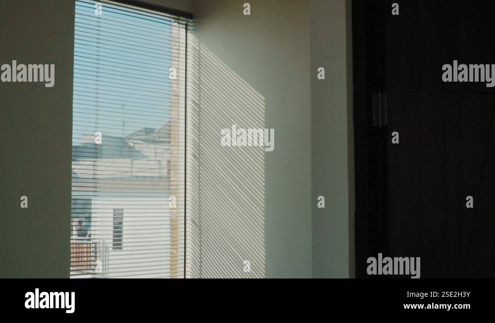 Rays of setting sun through the roller blinds on window, Sunshine over ...