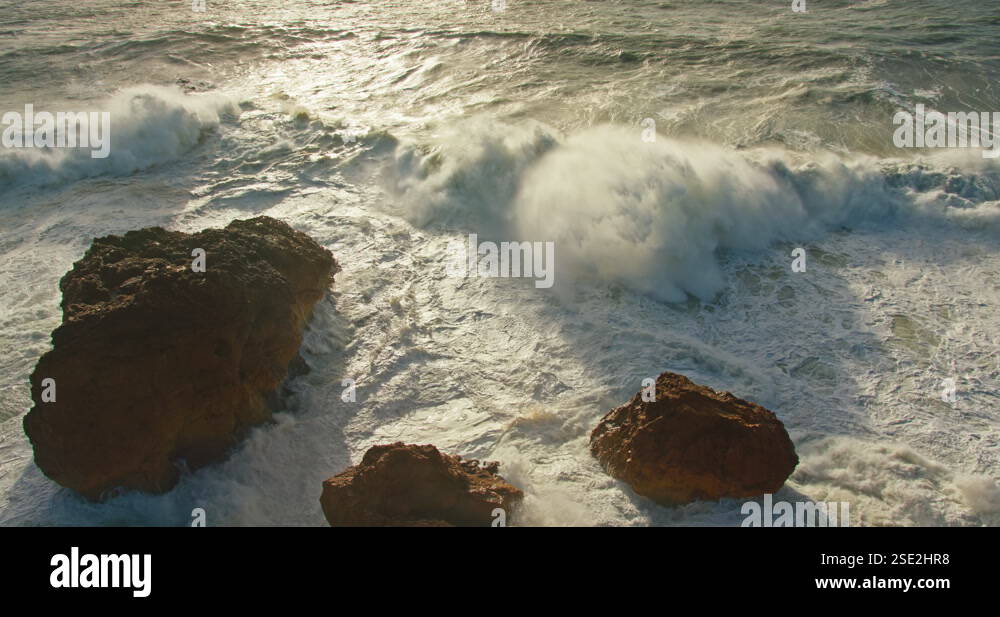 Nazare, Portugal. Footage of the rocky cliffs surrounded with high tide ...