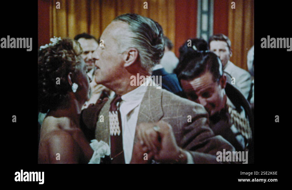 1950s: Woman on stage. Two men try to make way through crowd to woman ...