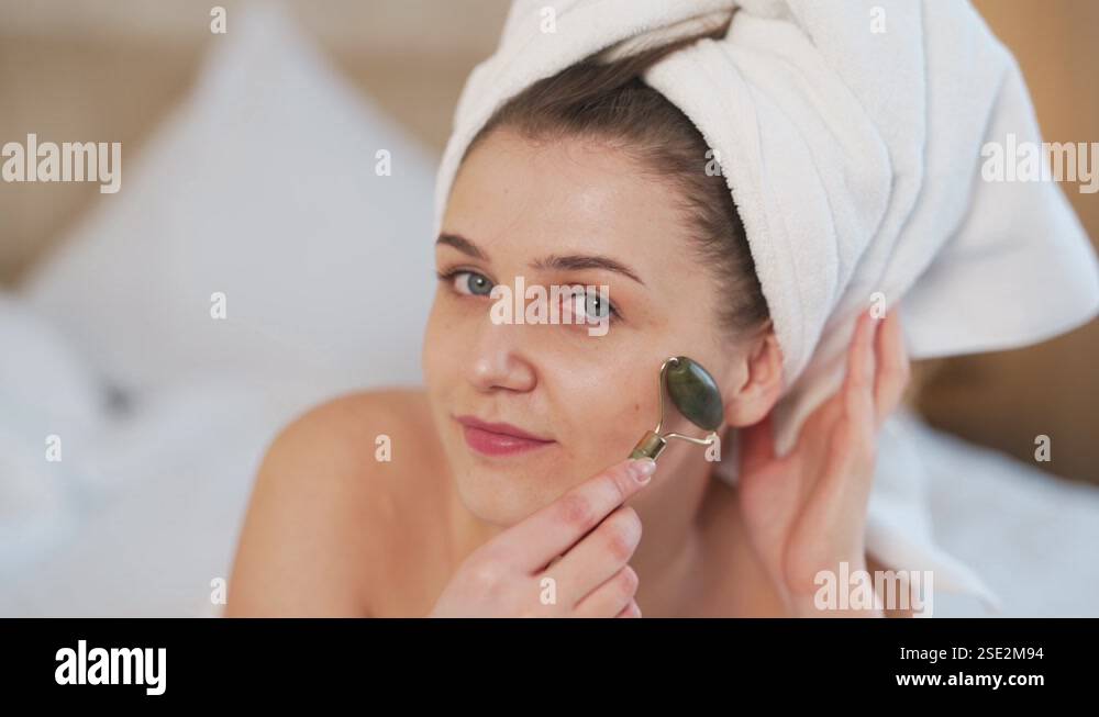 beautiful young girl doing a facial massage with a jade roller massager Stock Video Footage - Alamy