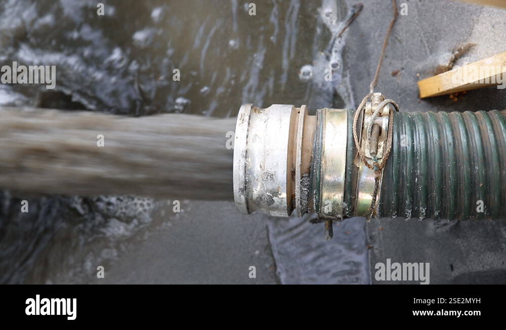 Close-up big pipe of power pump machine pouring mud sludge waste water ...