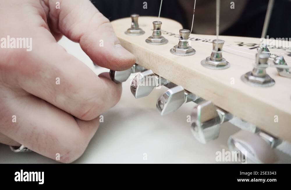 Man changes the strings of the guitar. Tuning keys detail 4K Stock ...