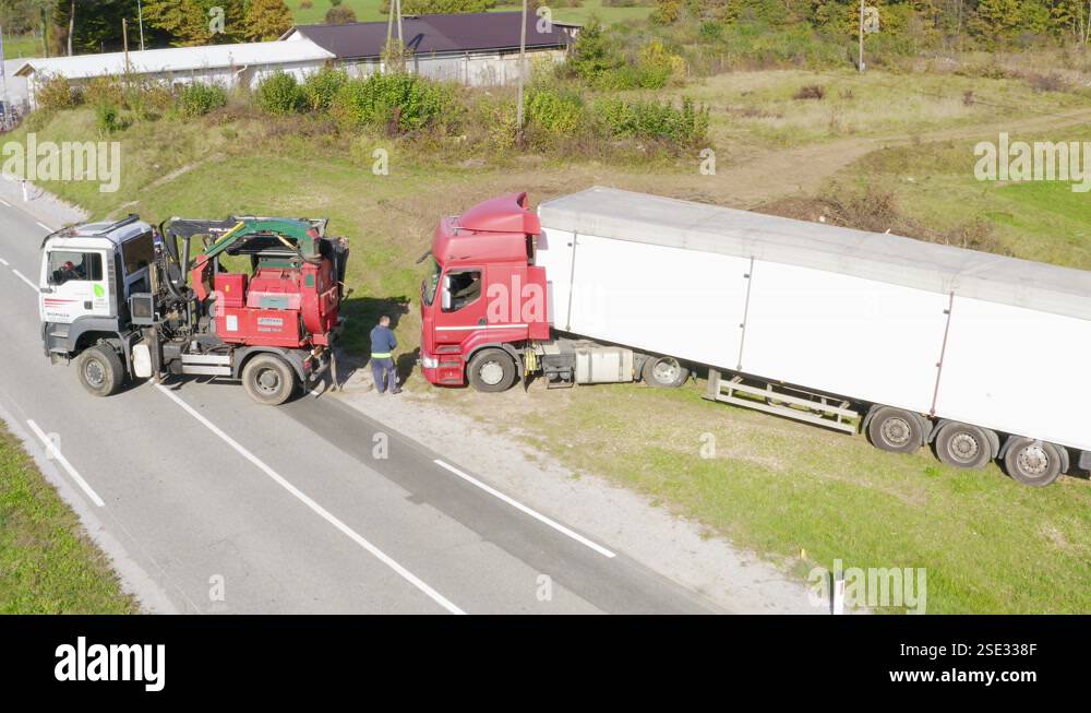Driver Attaching Towing Vehicle's Rope to Semi Truck on the Roadside ...