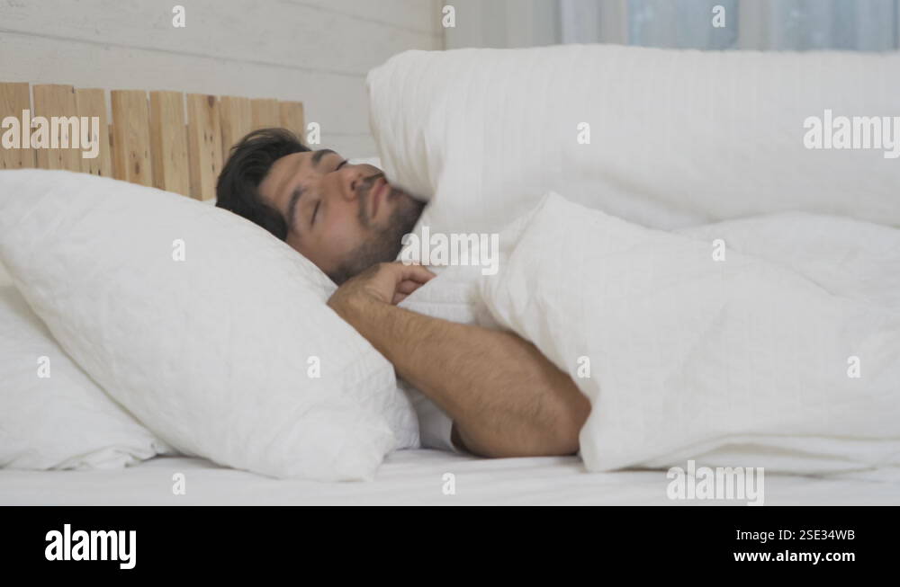 Sleepy middle east young man sleeping. People lying on bed in bedroom in earl Stock Video ...