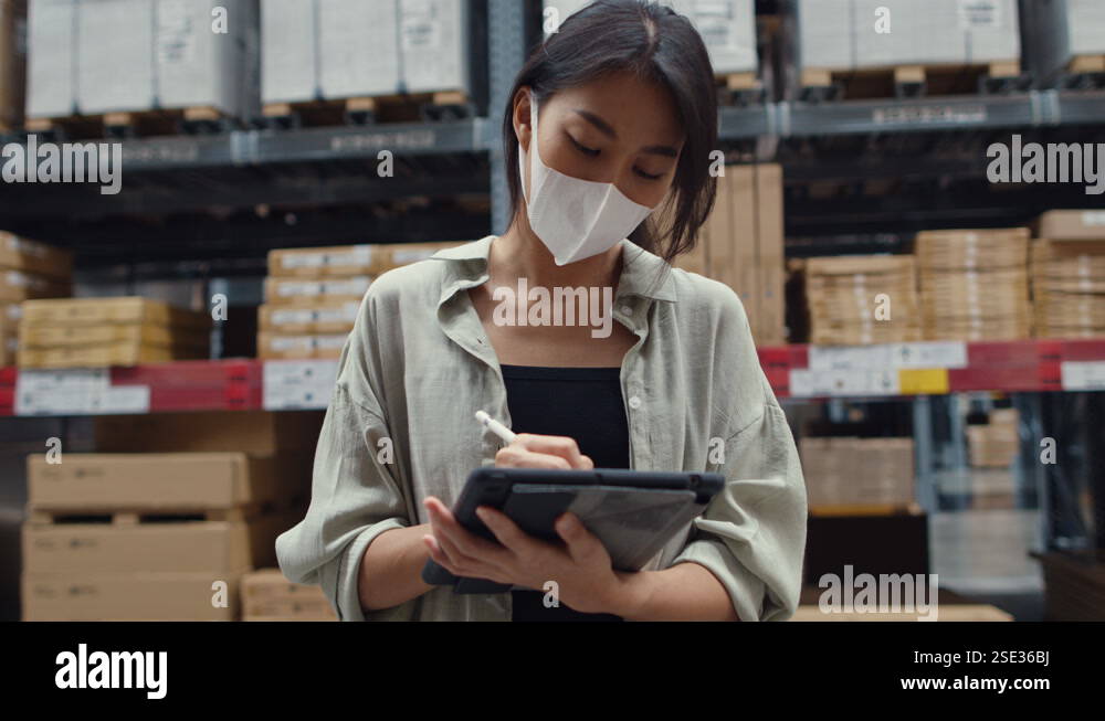 Businesswoman wear mask using tablet check inventory levels in shopping center Stock Video ...