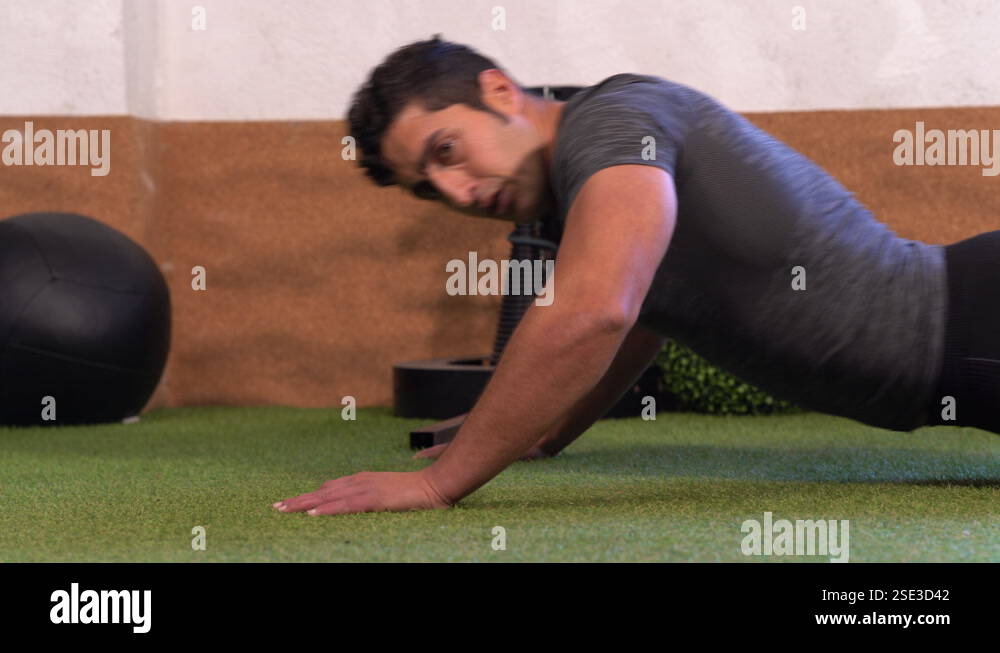 muscular man performing abs exercise sliding body on floor abs workout ...