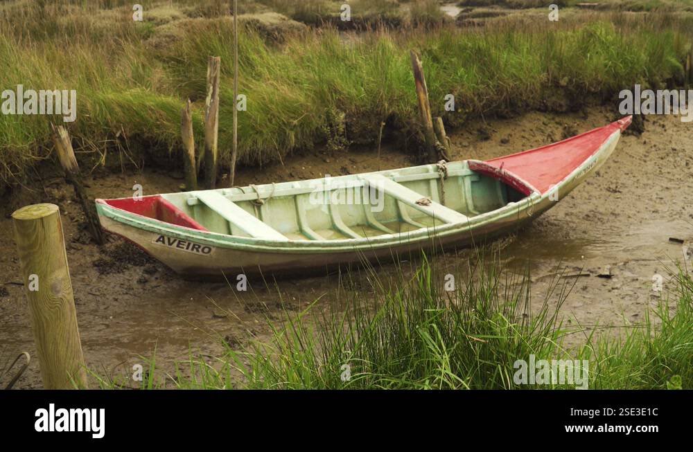 4K old wood fishing boat stranged on the muddy banks of a low tide ...