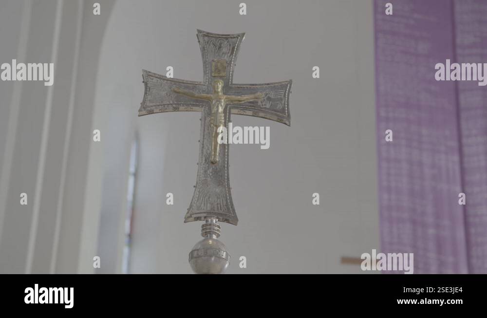 gold and silver cross in the chancel of a church. A banner with prayers ...