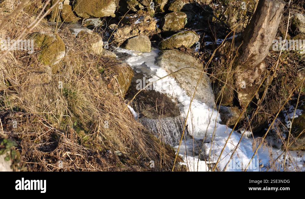 little brook flews down a small waterfall in spring. half of the ...