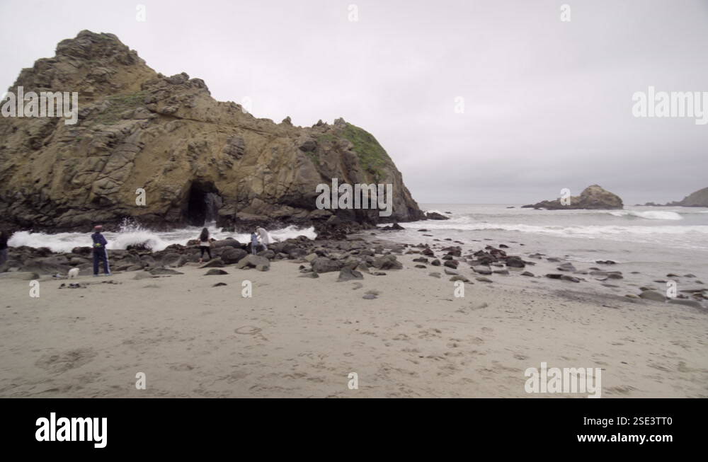 Panning: Tourists exploring famous Keyhole Arch at beach - Big Sur ...