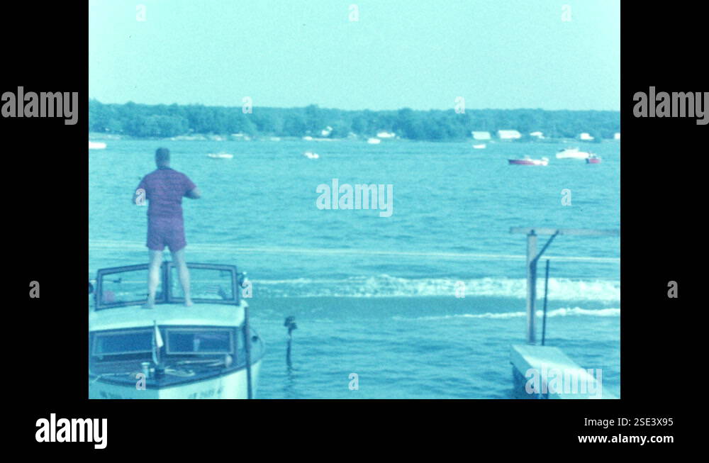 1960s: Shots of water skiers passing. Crowd of kids blowing up balloons ...