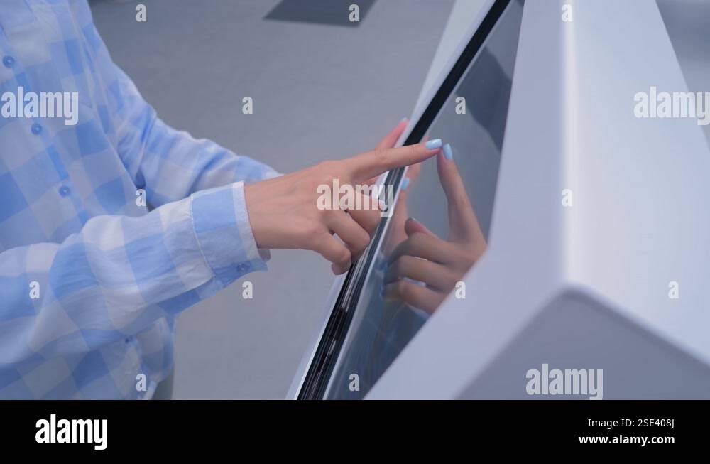 Woman hand using touchscreen display of interactive kiosk at exhibition ...