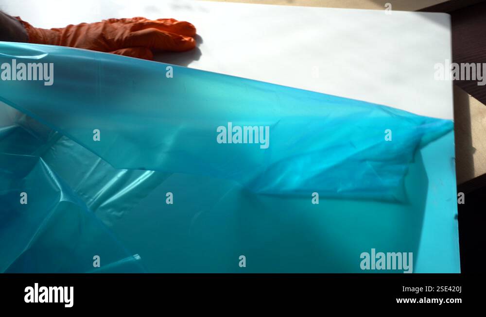 Remove the protective film from the panel. Worker removes the ...