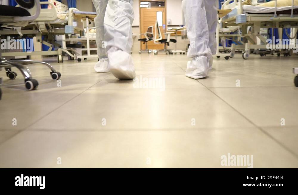 Doctors Wearing Full PPE Walking Along ICU Ward. Low Angle, Follow Shot ...