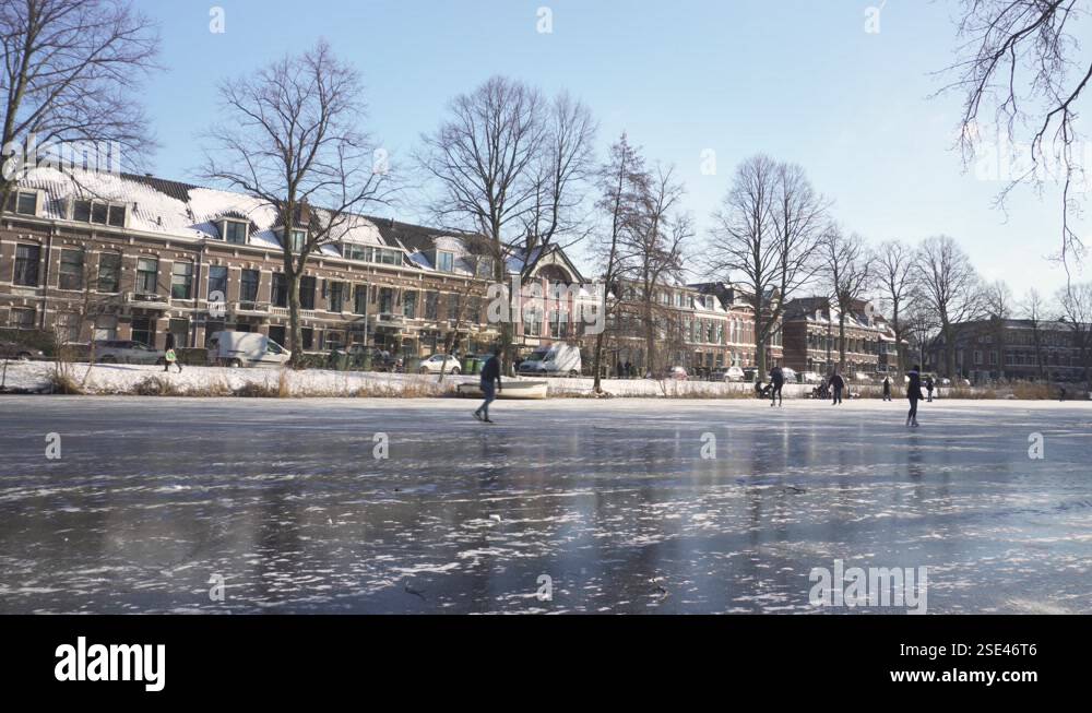 Dutch locals ice skating on frozen river in historic Leiden town Stock ...