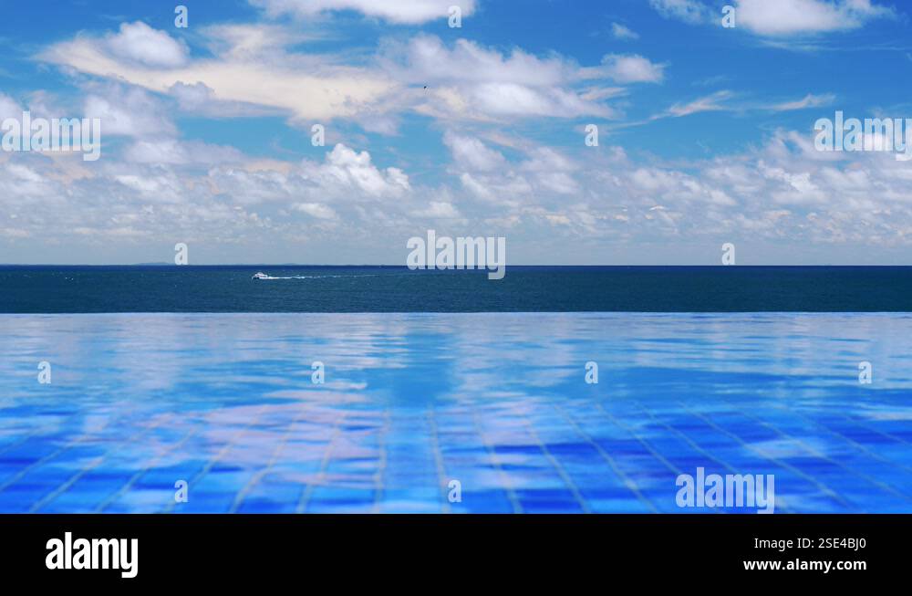 Borderless pool and ocean with blue water, sailboat at Morro de Sao ...