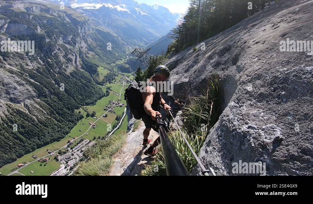 Strong man walks very carefully on the small path on the edge of the ...