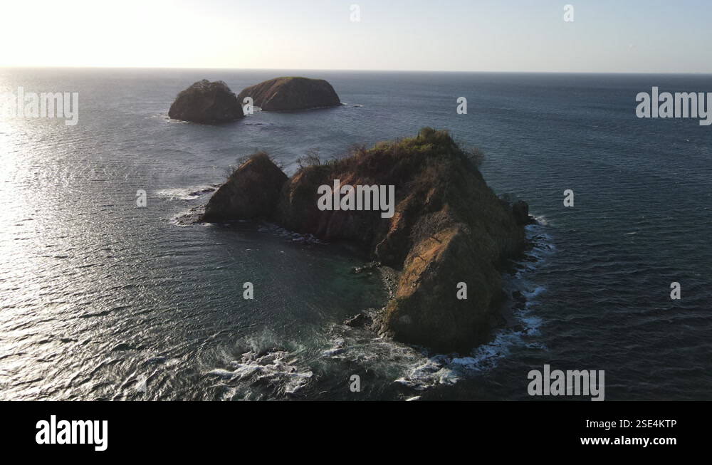 Rocky islands Guanacaste shore aerial shot sunset Costa Rica windy day ...