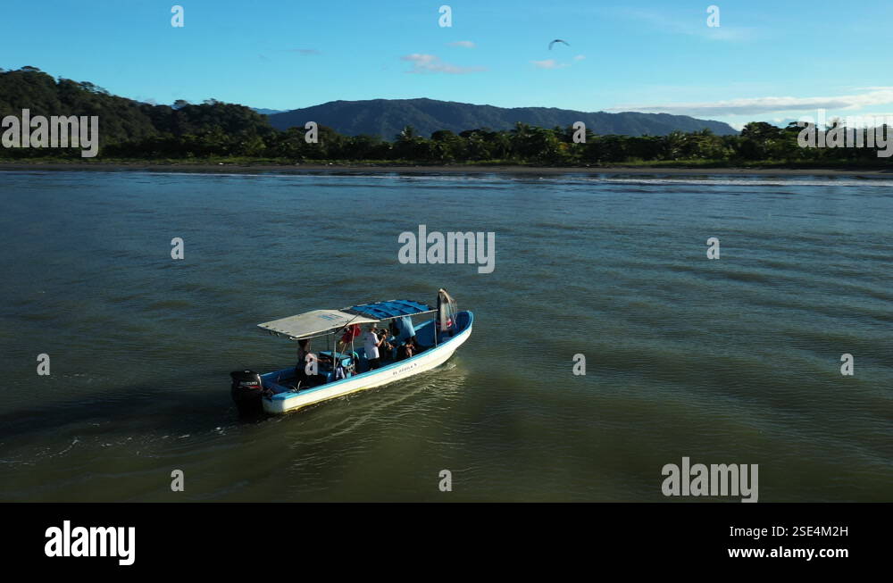 Fisherman throwing a fish net on a small boat Costa Rica Golfe dulce ...