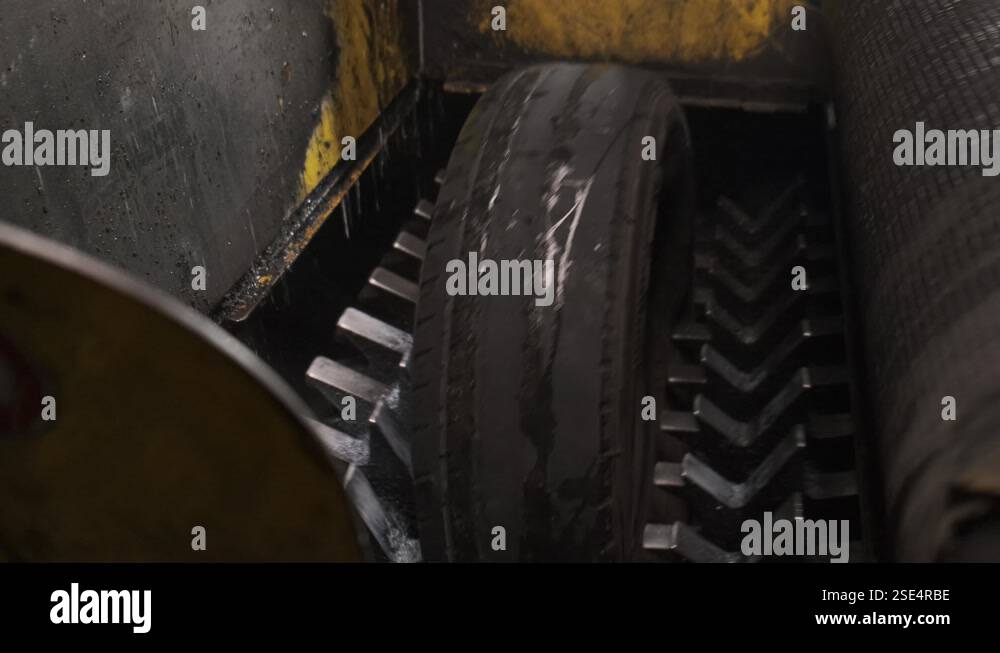 Tire recycling machine cutting tires into pieces. Old tires being ...