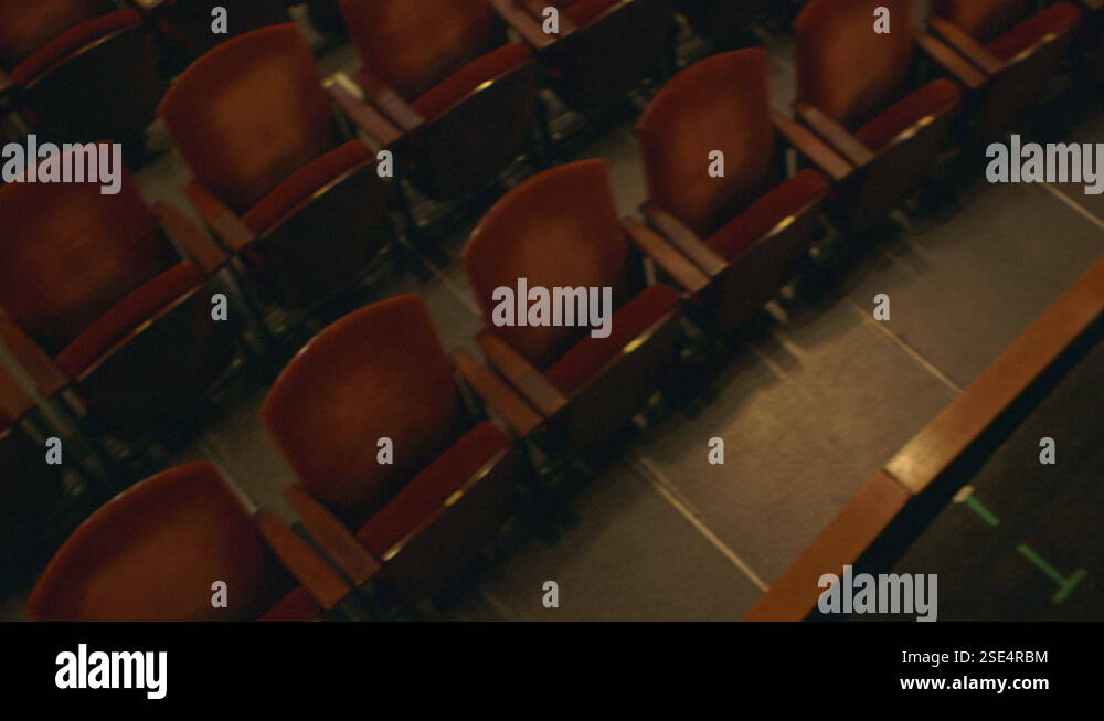 Push out from center stage and over empty plush red theater seats in an ...