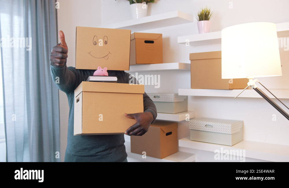 Thumbs up. Black man with carboard box over the head package books and ...