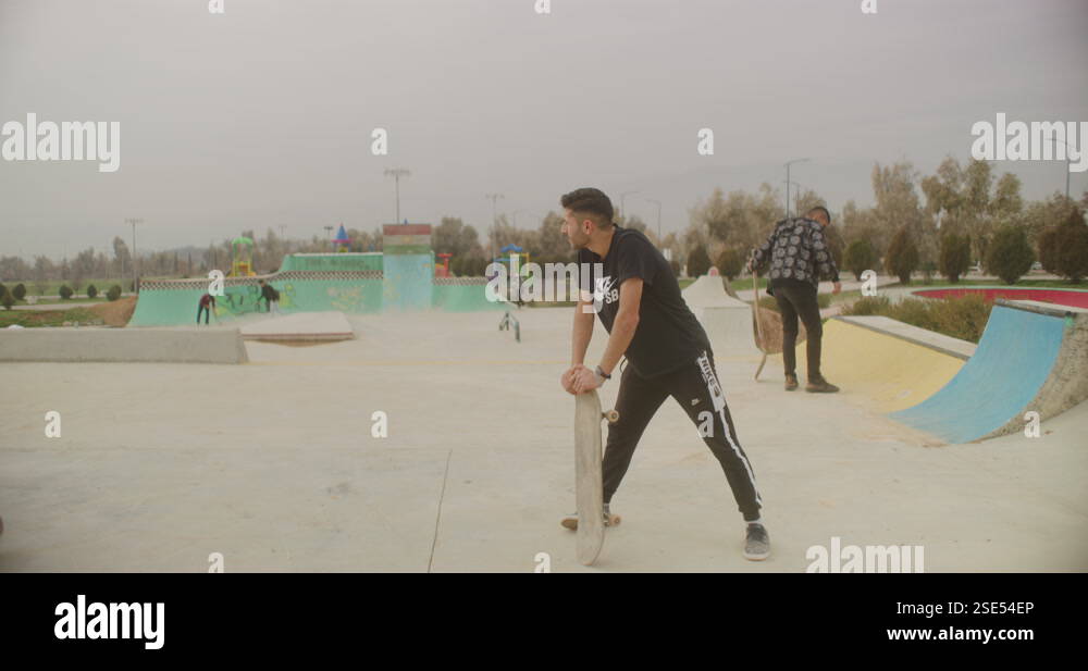 Man Takes Sand Off His Skateboard At The Suli Skate Park in ...