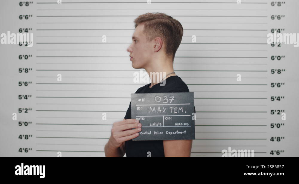 Side profile mugshot of male teenager holding cardboard. Young arrested ...