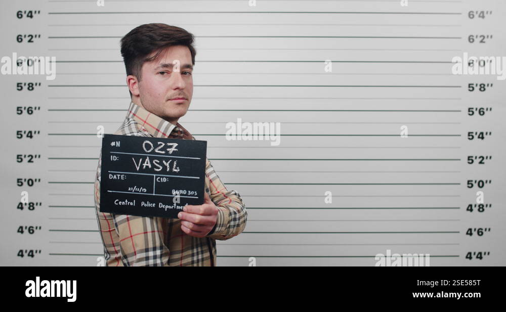 Side profile mugshot of male arrested looking to camera while standing ...