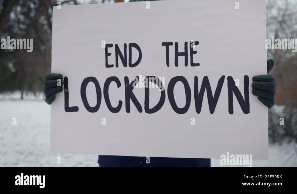 Man holding a sign that says End the Lockdown and demanding freedom at ...