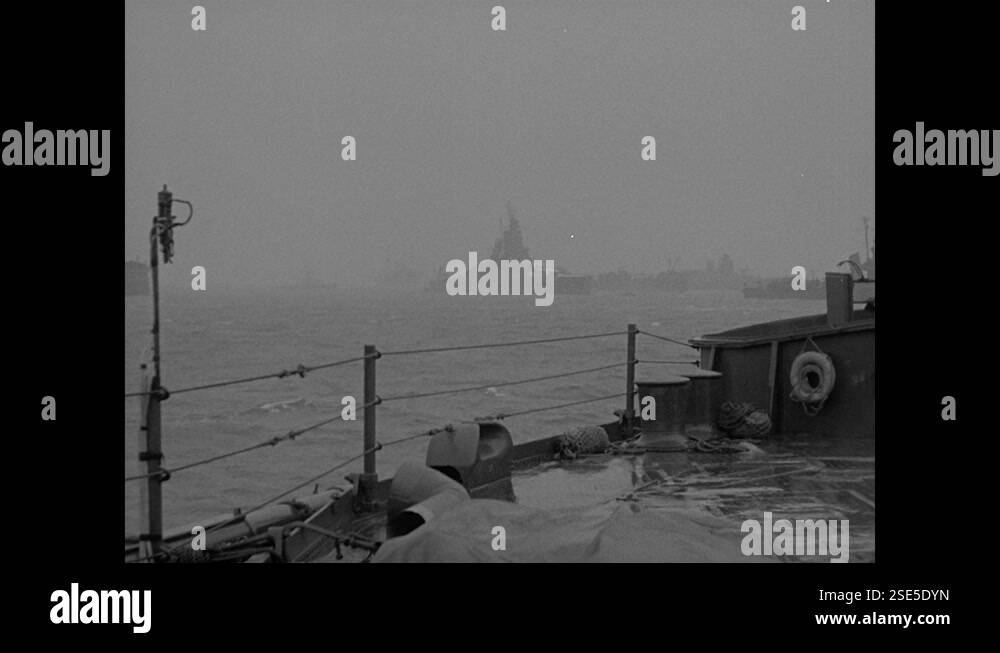 1940s: On deck of ship at sea, looking at fleet of Navy ships. Sailors ...