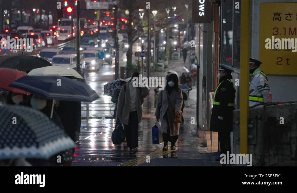 Two Security Guards Watching People Walking In The Street On A Rainy ...