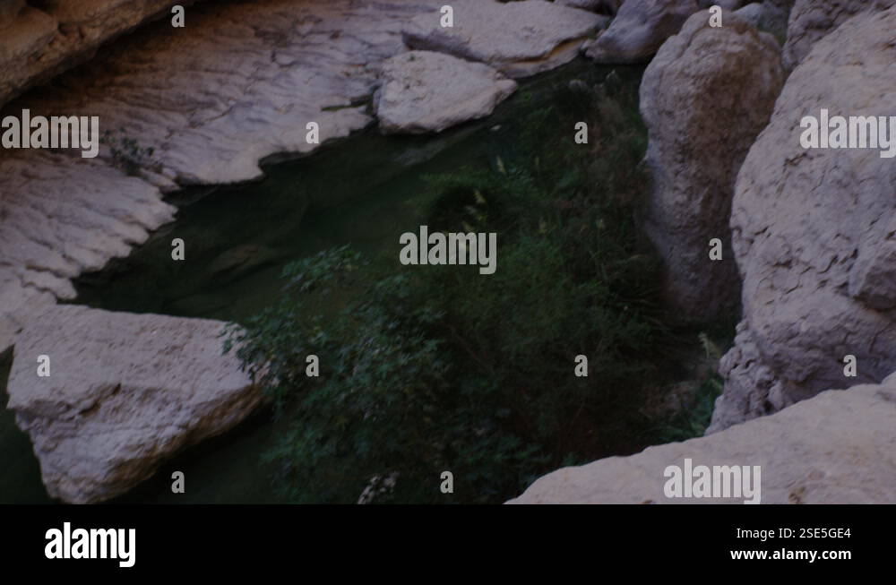 The turquoise pools of Wadi Shab canyon in Oman, wide shot tilt up and ...