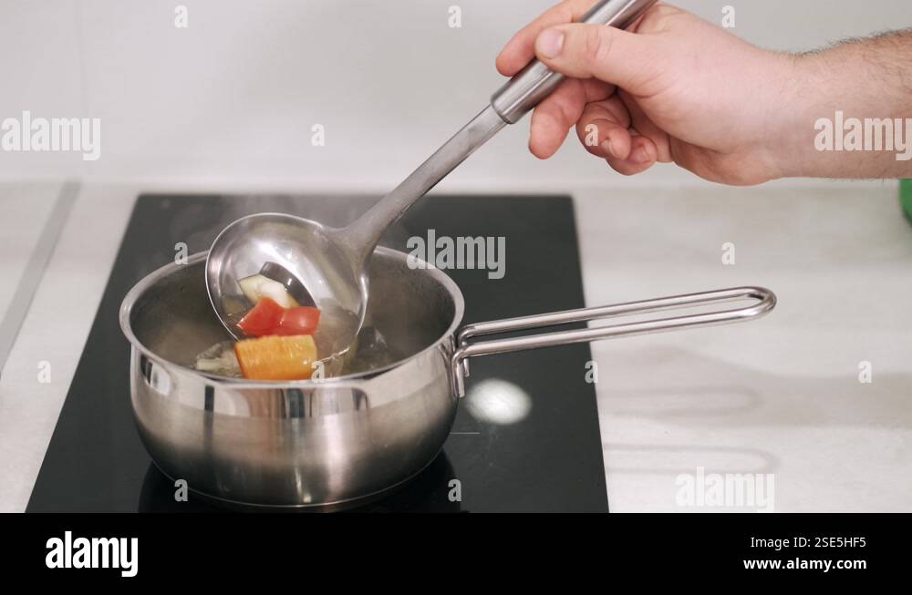 Man boiling vegetables preparing them for soup in stew pan Stock Video ...
