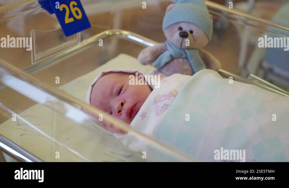 Newborn baby boy one hour after birth inside crib in maternity hospital ...