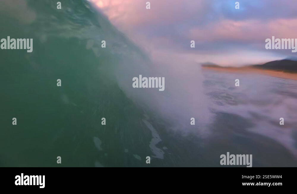 Ocean wave breaks on shore at sunrise. Atlantic Ocean's wave breaks on ...
