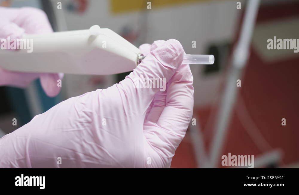 close up doctor places needle on device for gas injections of ...