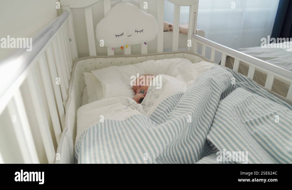 newborn baby infant sleeping in bed little boy sleeps in a crib in the ...