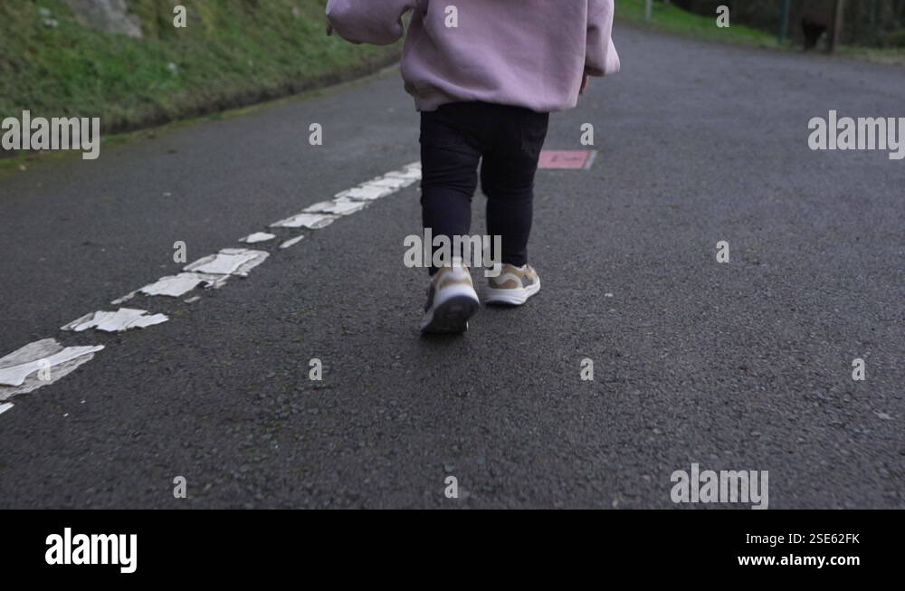 Slow Motion Back View of Toddler Running on Asphalt Trail in Park Stock ...