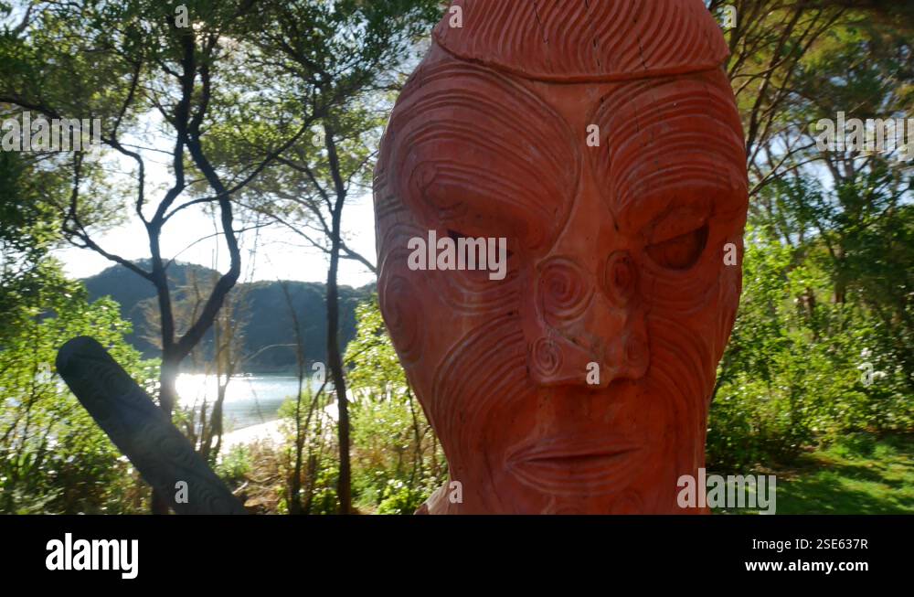 Red wood carving of Maori warrior with club on Abel Tasman Trail Stock ...